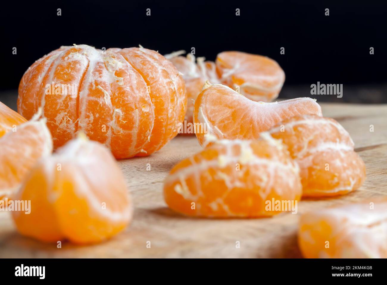 peeled ripe juicy tangerine, divided into slices of tangerine on a ...