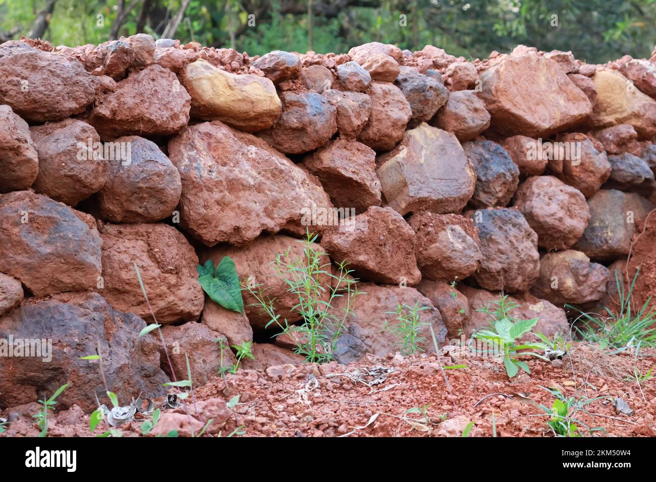 fence wall constructed from large red stones and forming beautiful ...