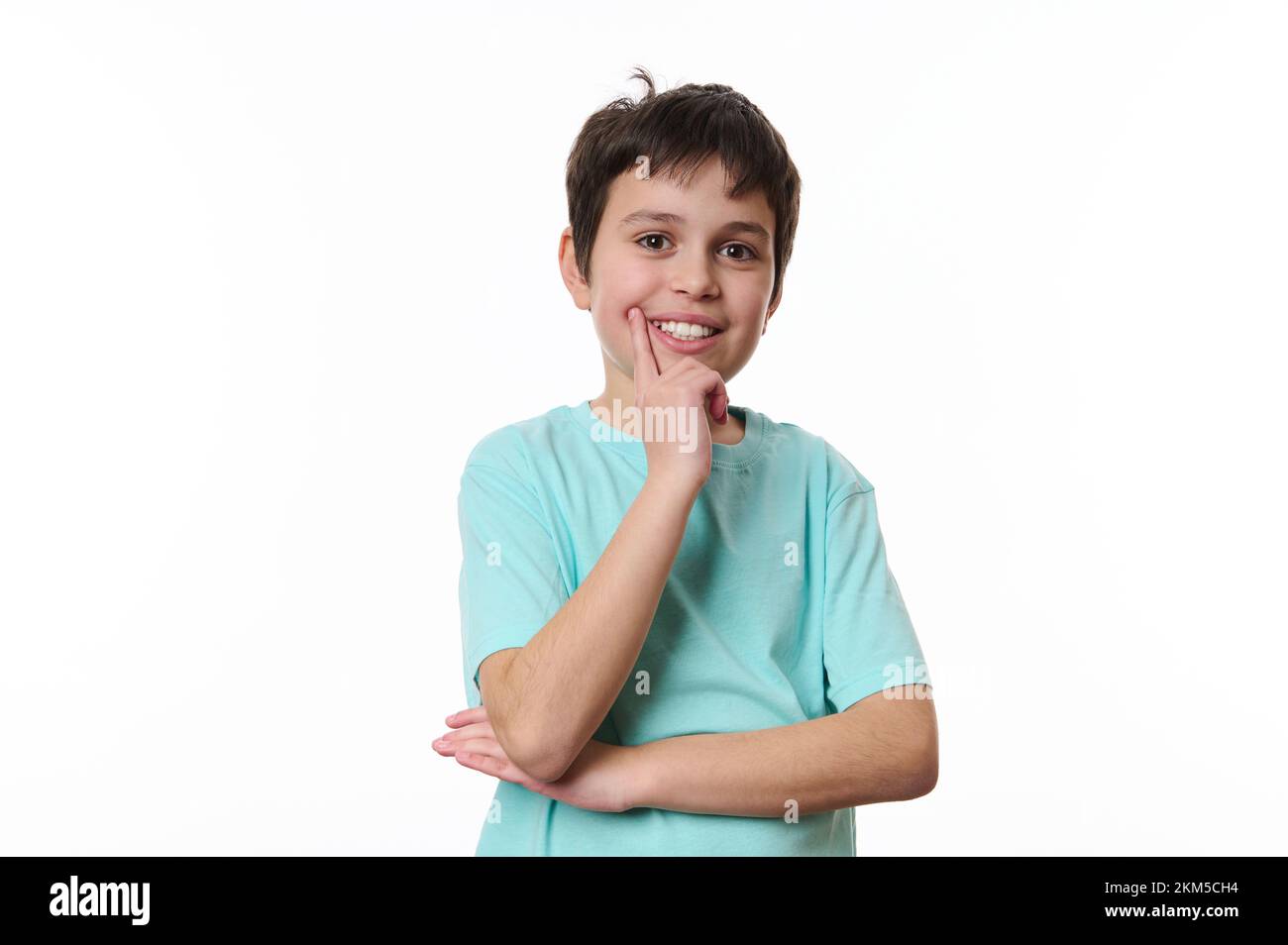 Happy child boy olding his hand at chin and cutely smiling ...