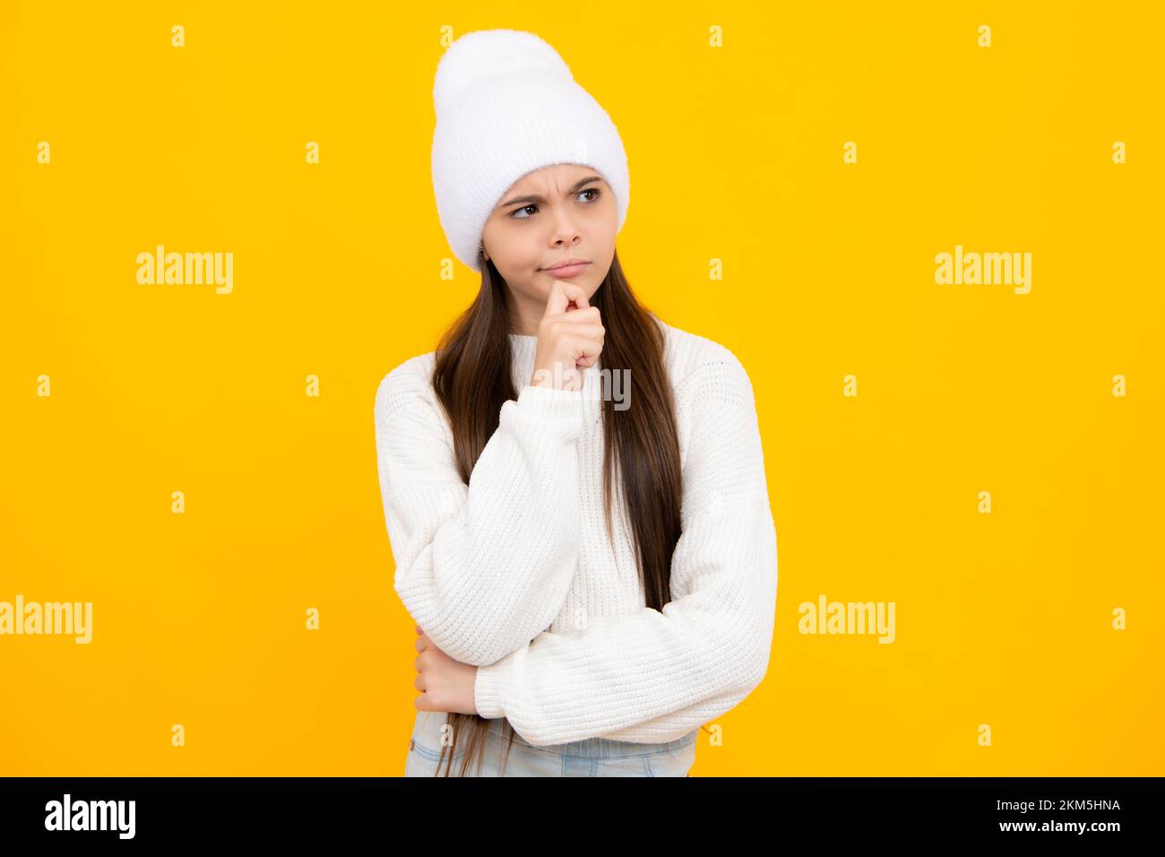 Thoughtful teenage child girl on yellow background. Portrait of a kid ...
