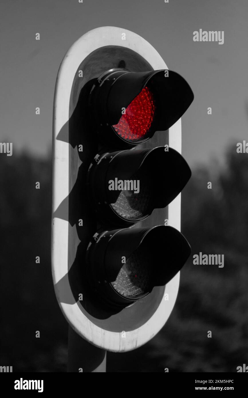 A red light flaming on a grayscale traffic light Stock Photo - Alamy