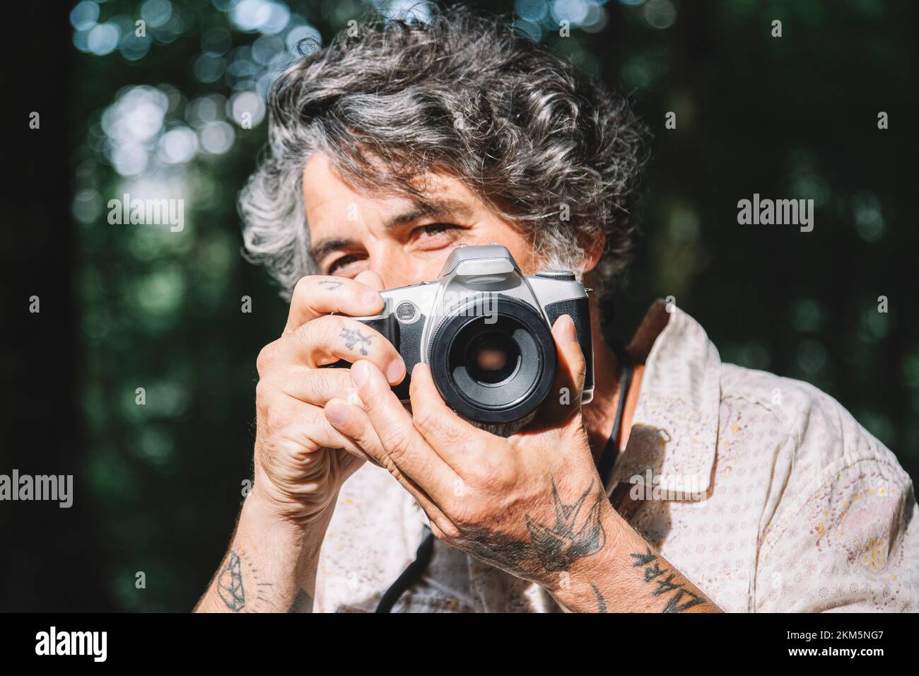 A portrait of a man looking behind the viewer of a vintage camera Stock ...