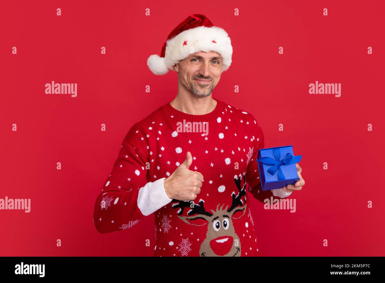 Santa with gift box. Portrait of christmas santa man on red studio ...