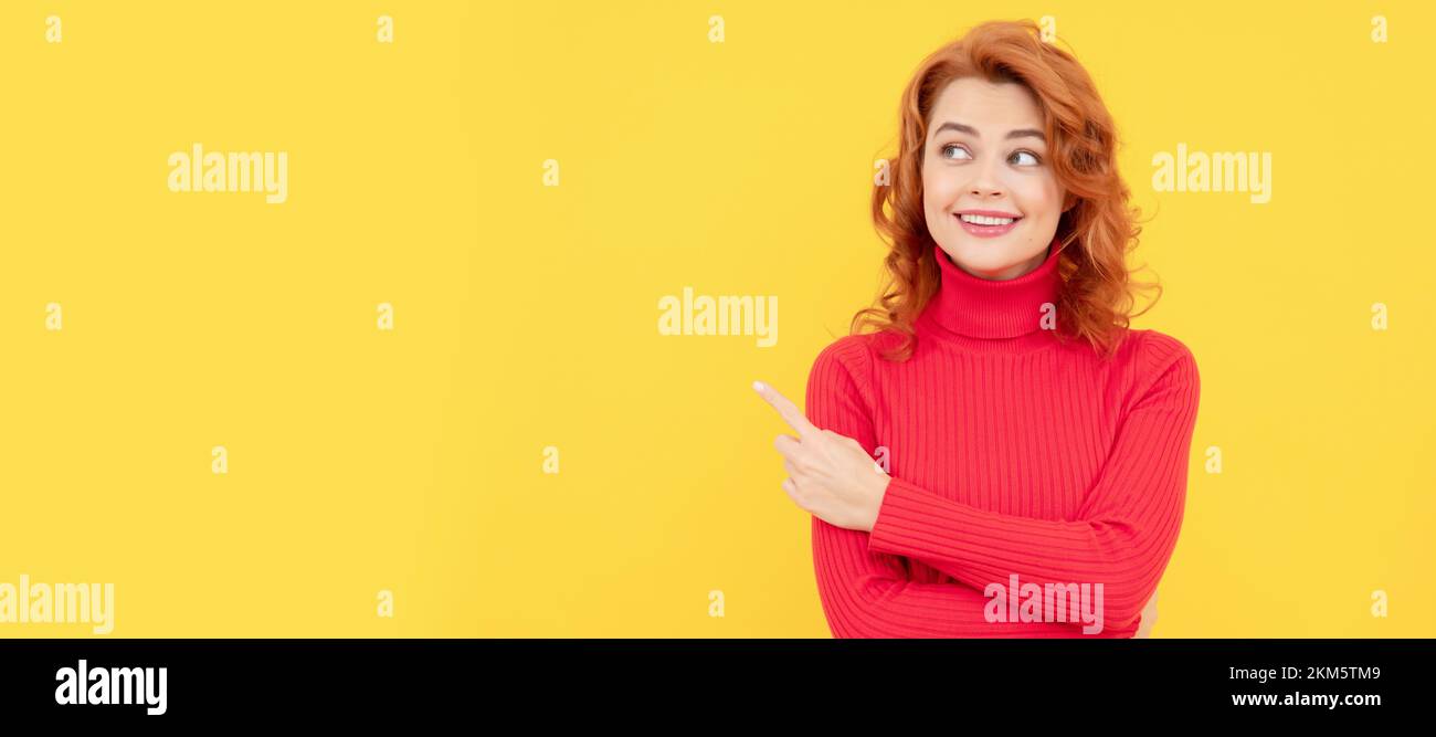 happy redhead woman pointing finger, copy space. express positive ...