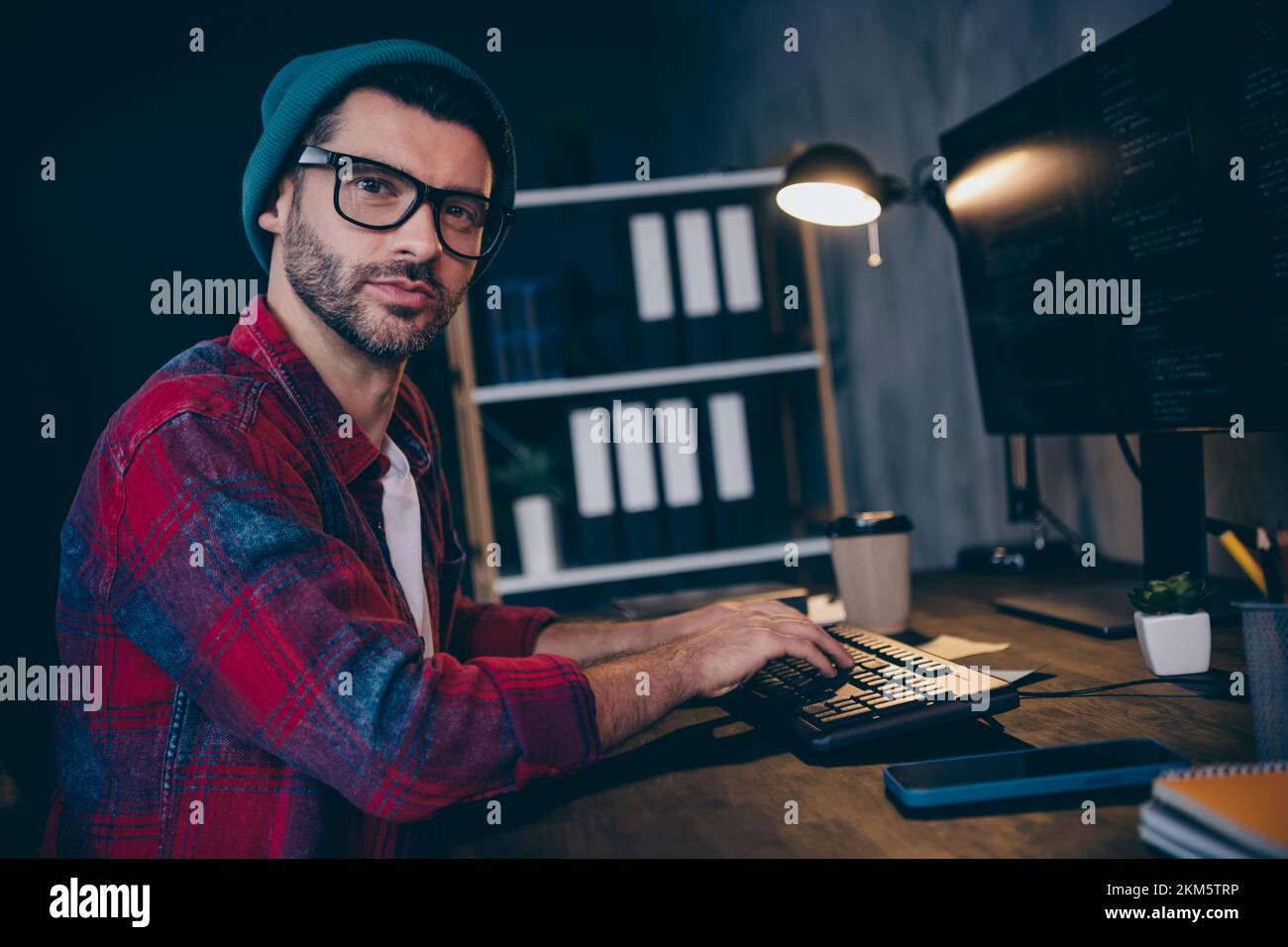 Photo of cool serious coder dressed hat glasses fulfilling task modern ...