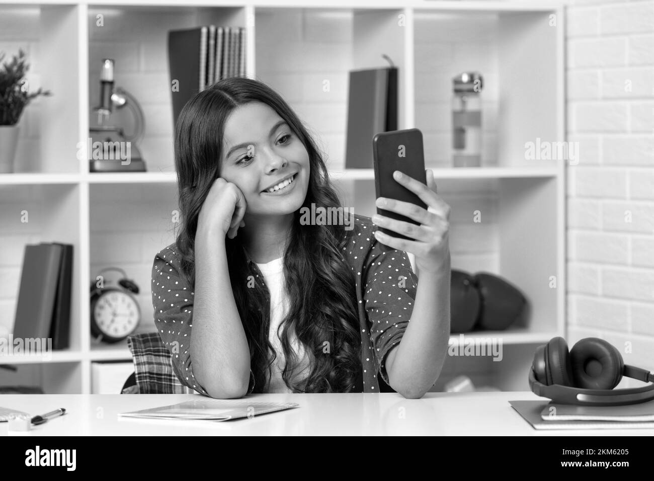 happy child curly hair making selfie on phone in classroom, vlogging ...