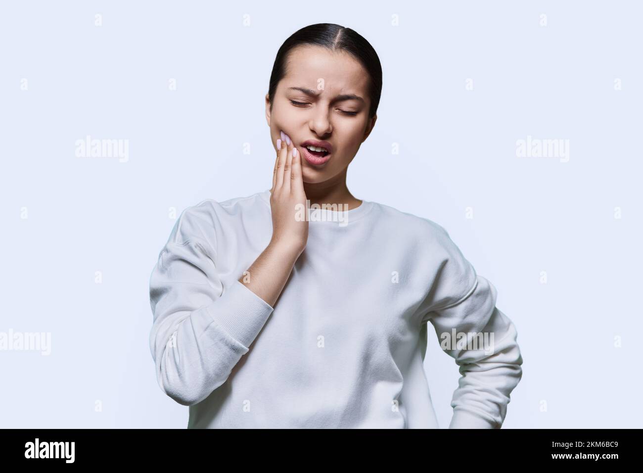 Teenage girl having toothache, on white studio background Stock Photo ...