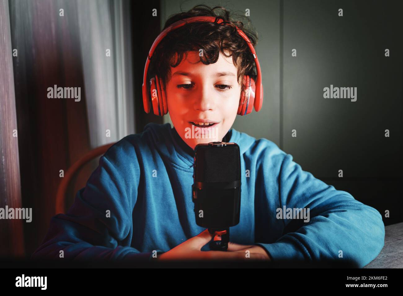 Little vlogger wannabe - kid in his room talking on the microphone and ...