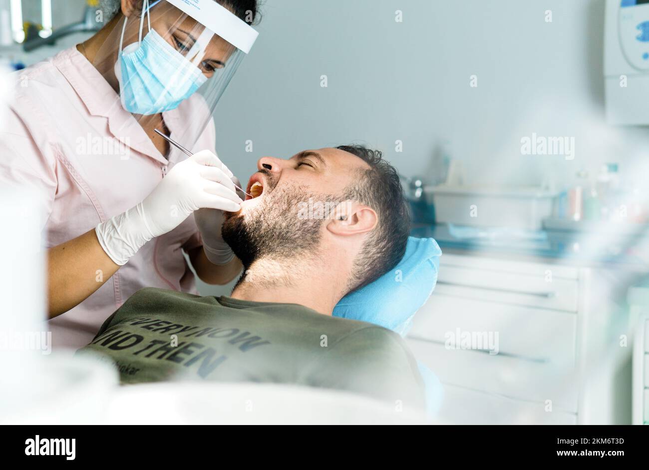 Female doctor operates a patient wearing protective devices in the ...