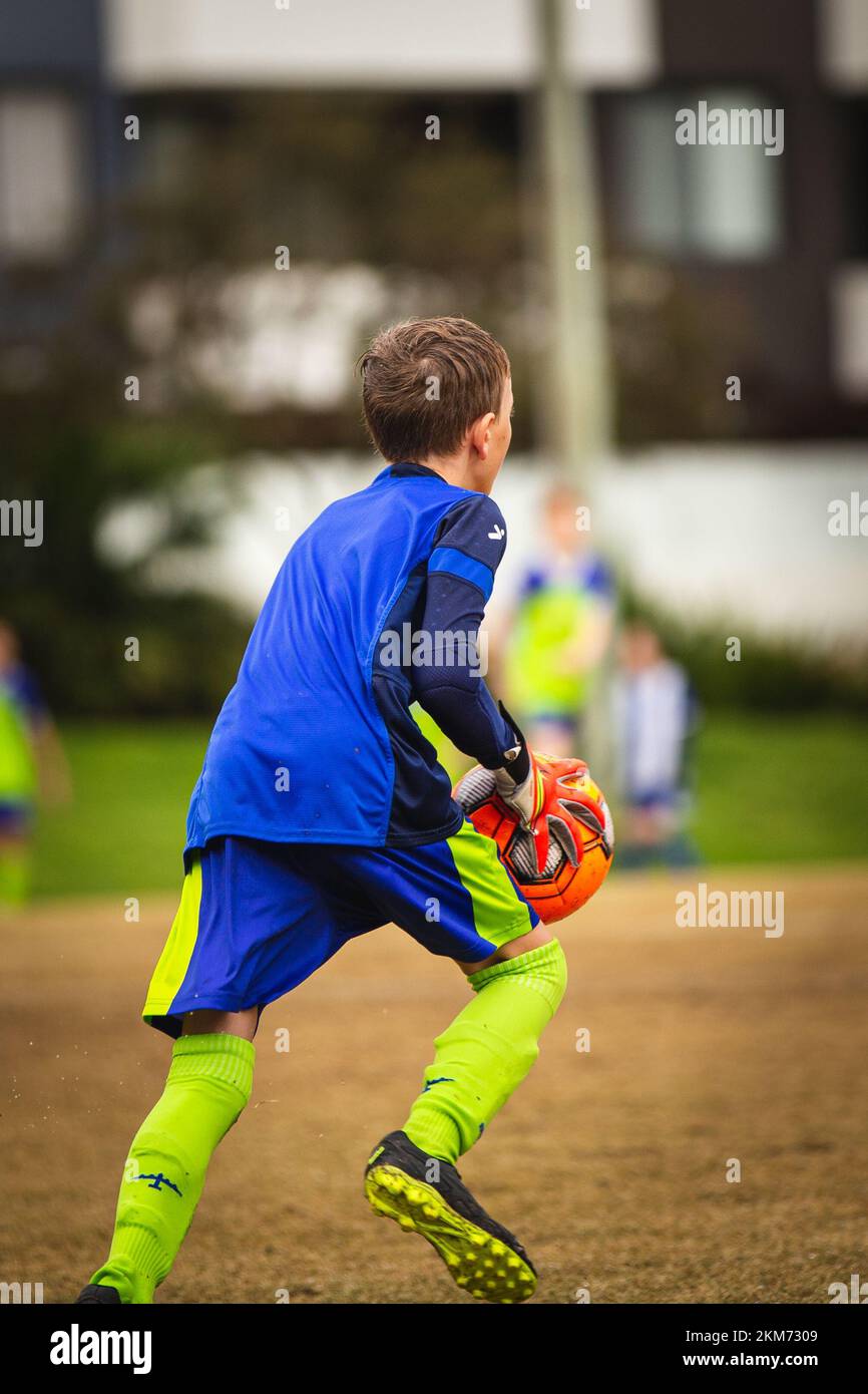 A rear view of a boy running and playing soccer Stock Photo - Alamy