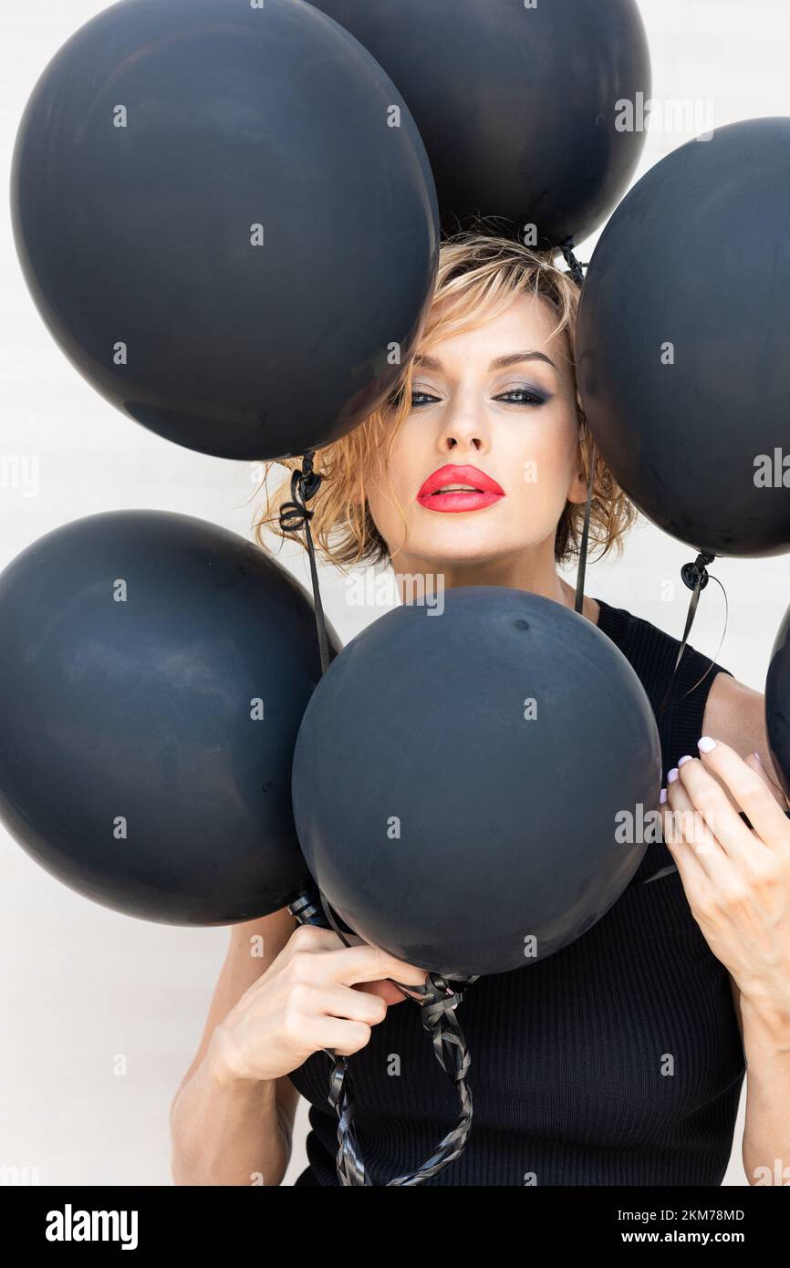 Beautiful woman of model appearance with dark balloons. Art shooting ...