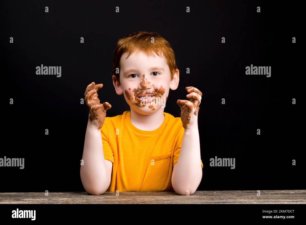 boy smeared in milk chocolate after nibbling and biting real cocoa ...