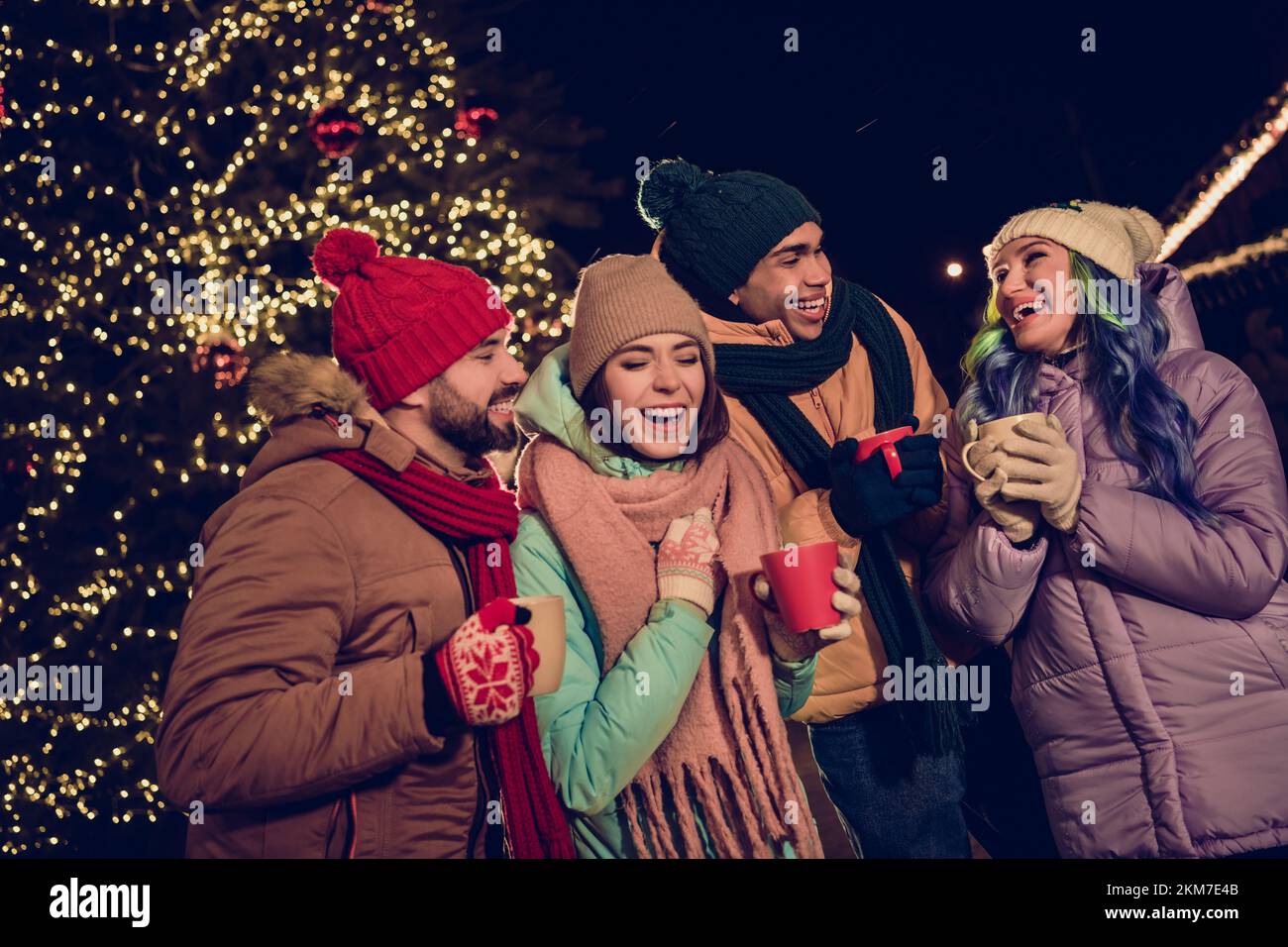 Photo of funky overjoyed group people enjoy hot tea mug speak laughing ...