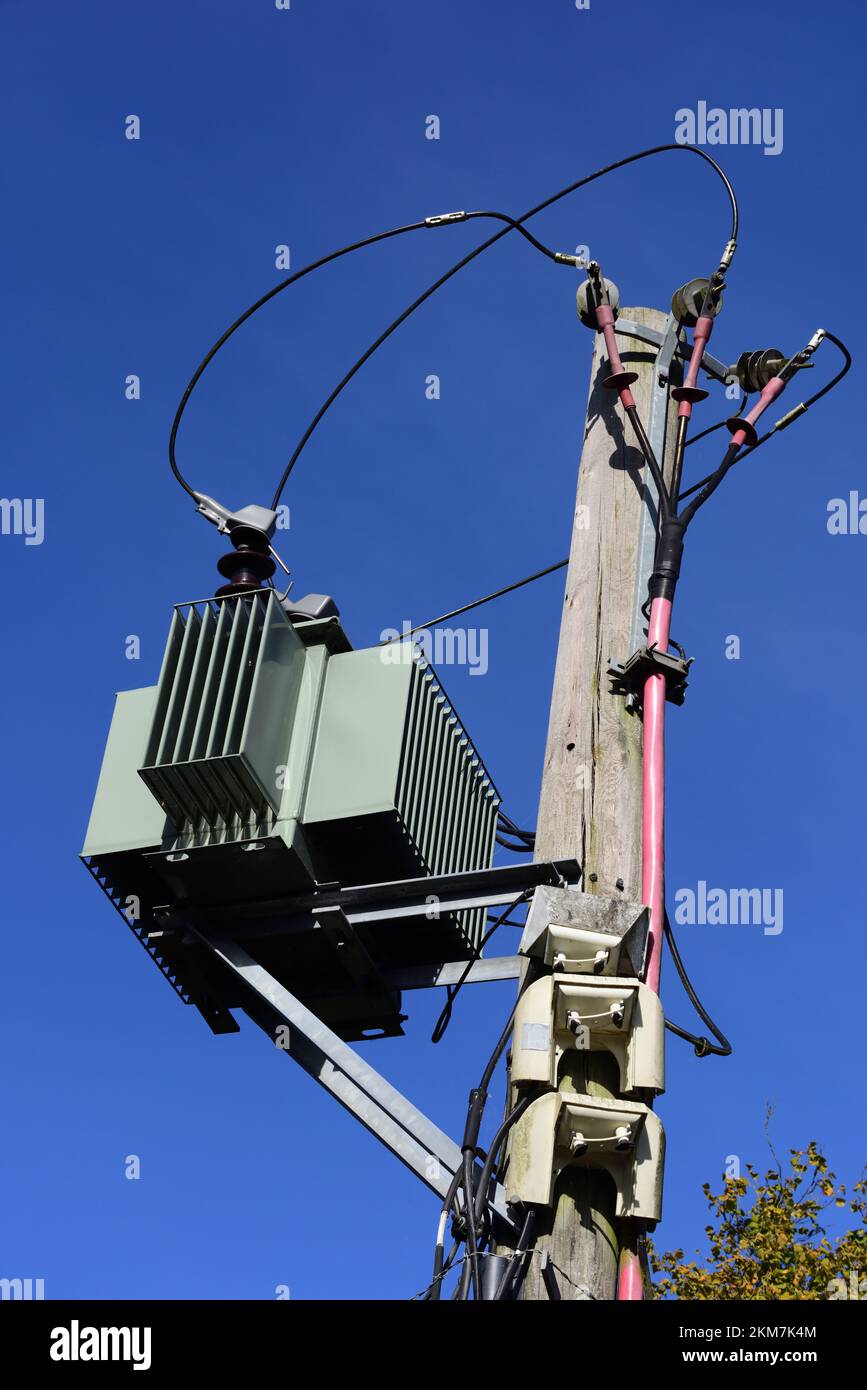 Overhead power cables on a post against a blue sky Stock Photo - Alamy