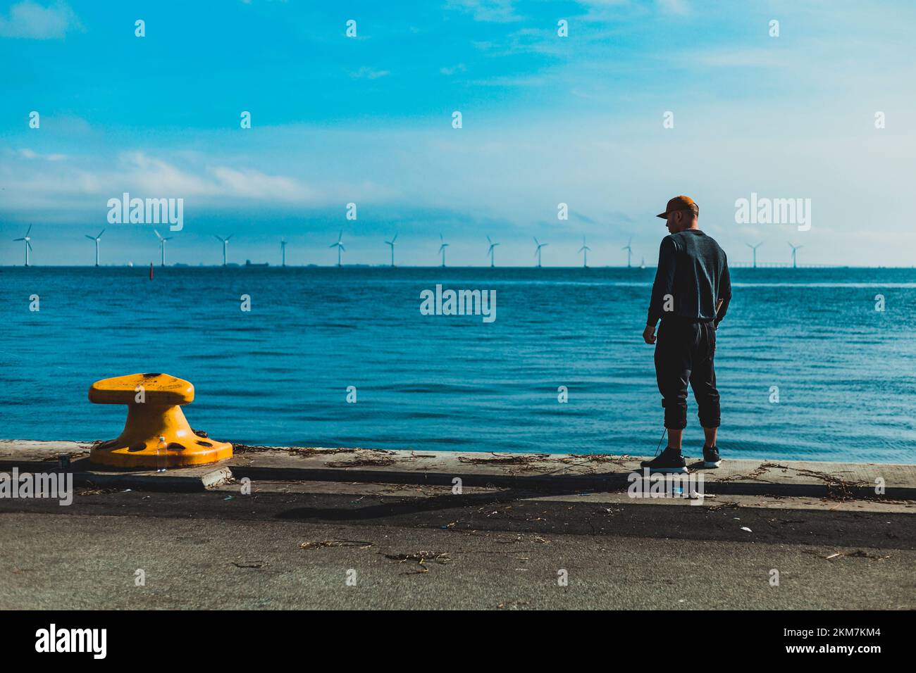 man standing by the shore in a seaside port Stock Photo - Alamy
