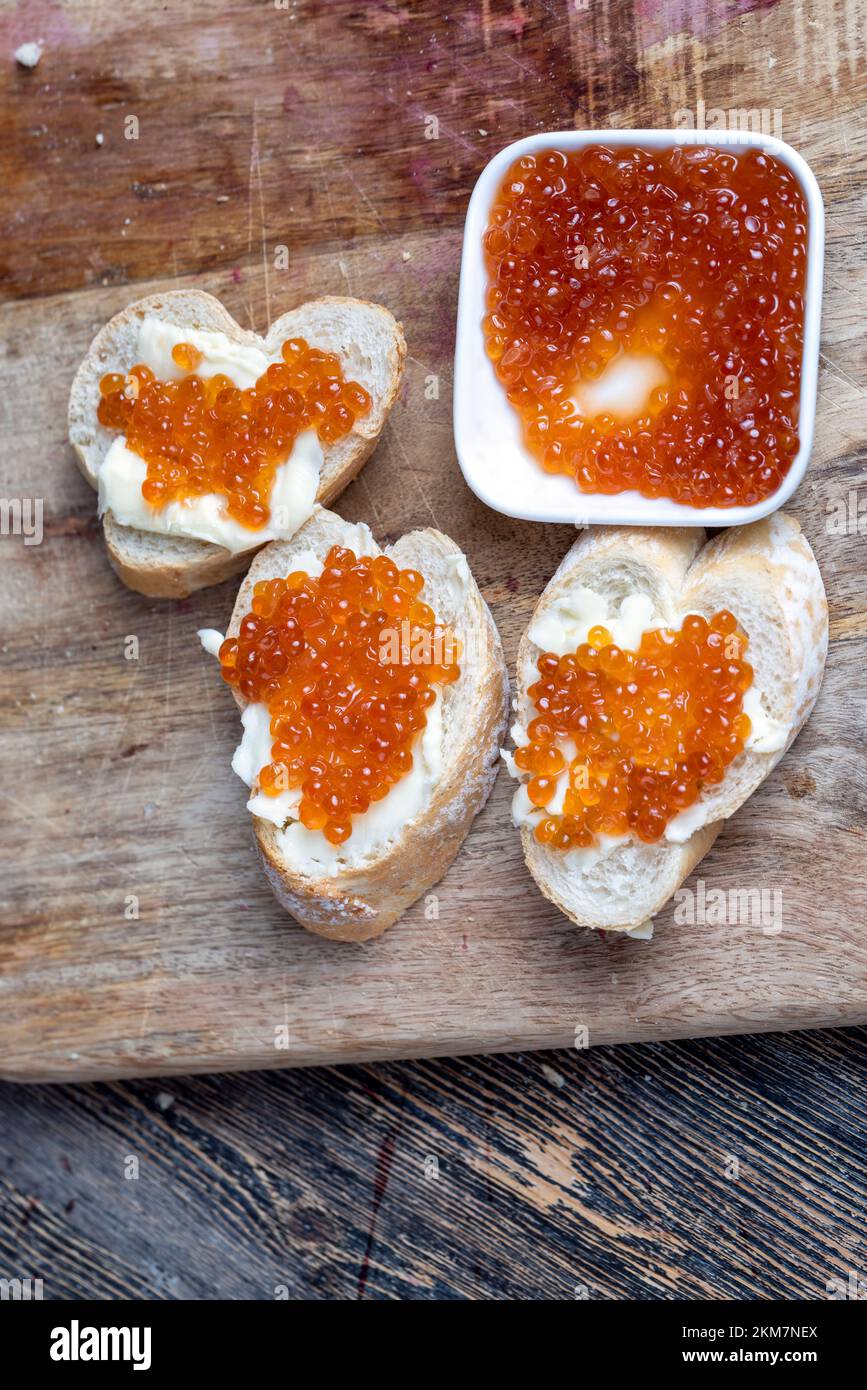 natural red salmon caviar with baguette and butter, making sandwiches ...