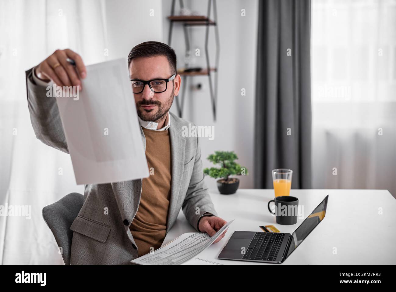 Handsome bearded adult man, checking the numbers his business is making ...