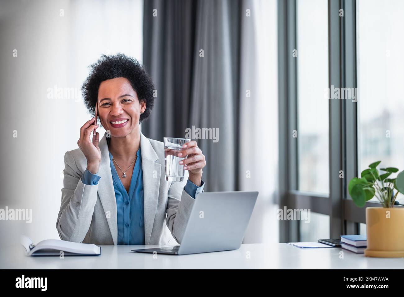 Picture of lovely adult female entrepreneur, holding a glass of water ...