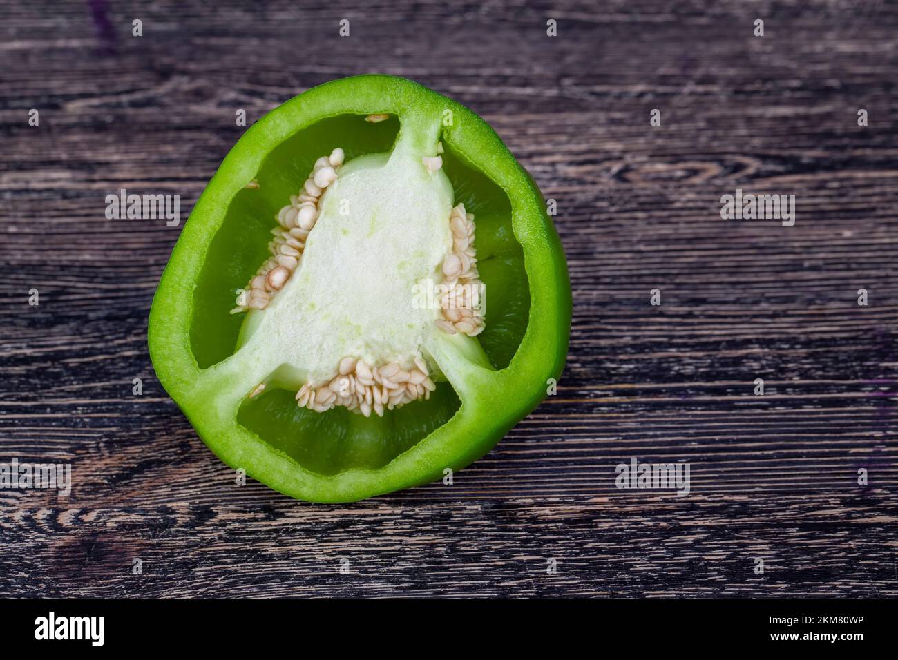 ripe green pepper cut in half, green bell pepper cut in half on a black ...