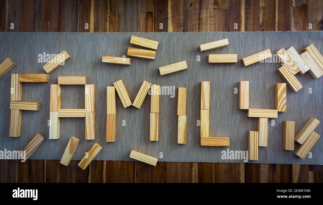 The word family spelled using Jenga blocks on a wooden surface Stock ...