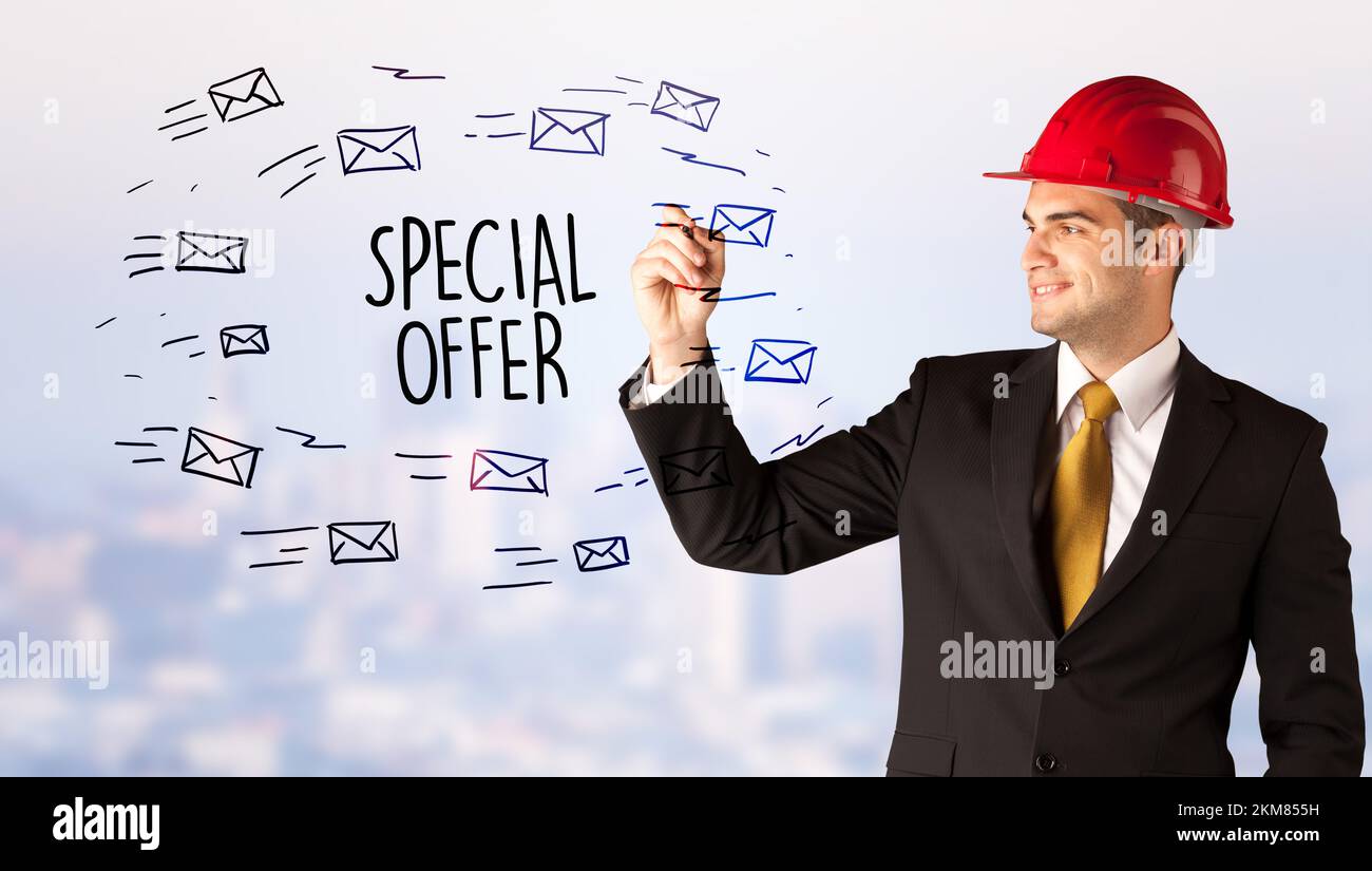 Young businessman with helmet drawing sale sign Stock Photo - Alamy