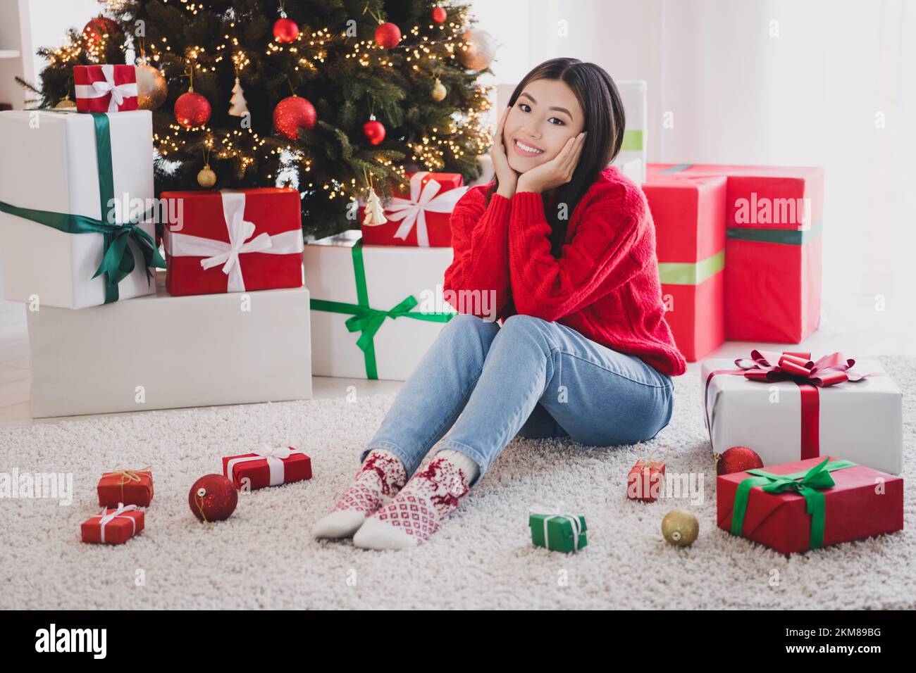 Photo of adorable dreamy girl wear xmas red pullover sitting under noel ...