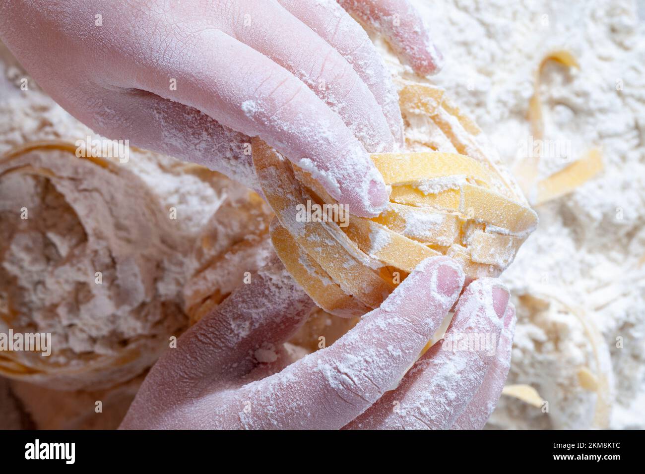 wheat flour pasta and wheat flour on a board, dry uncooked noodles with ...