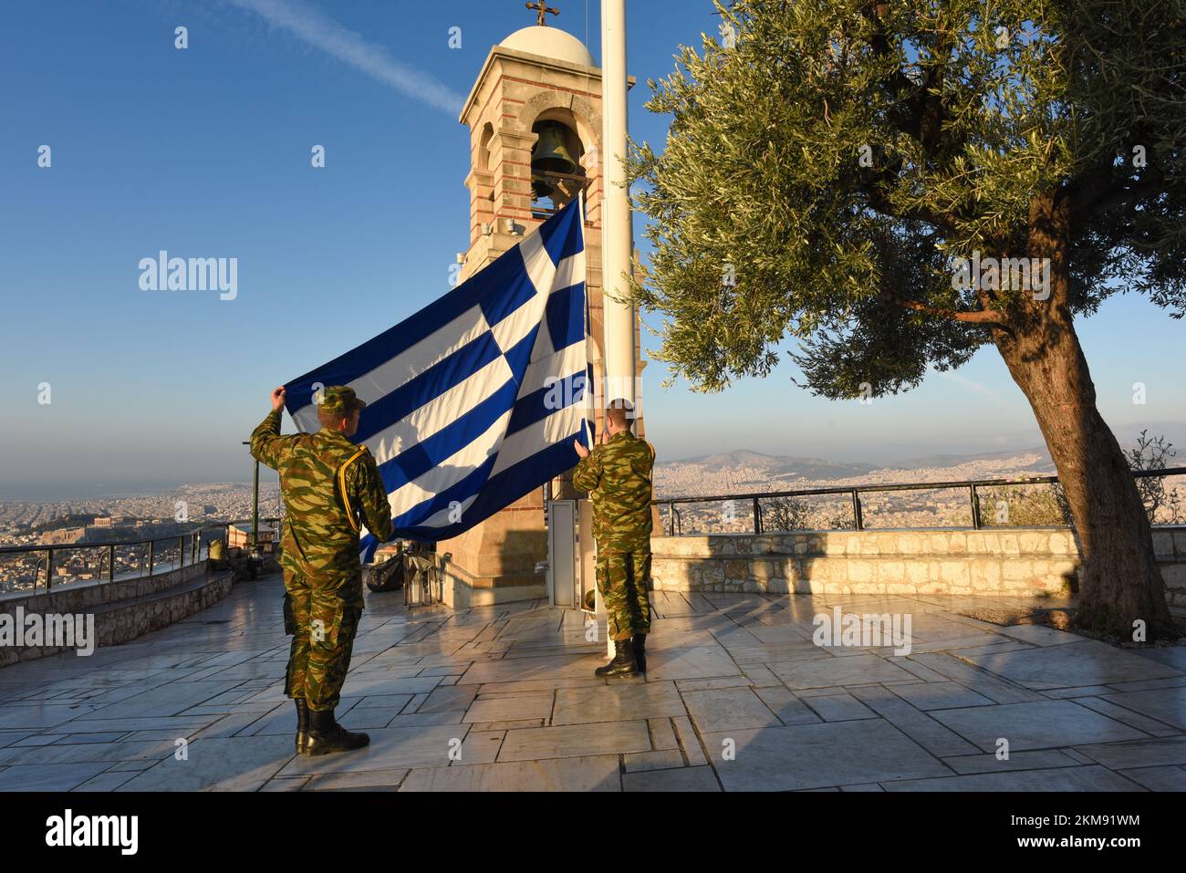 Greek soldiers raising Greek flag at sunrise on Lycabettus Hill above ...