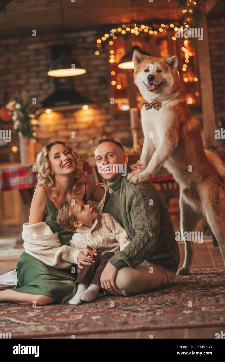 Portrait of happy family in knitted beige sweaters waiting Santa indoor ...