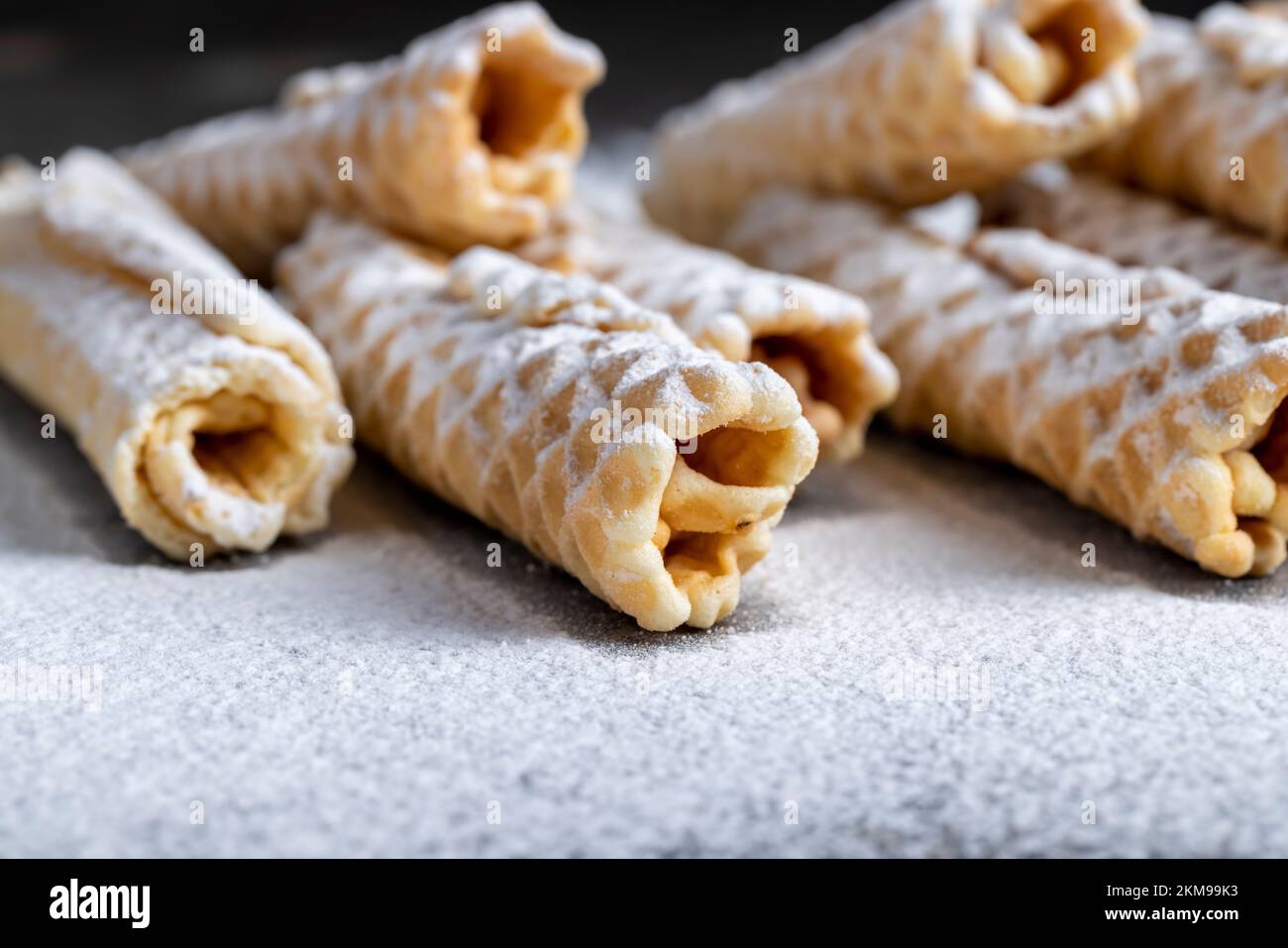 thin crispy waffles lie on a black table, sweet food for desserts Stock ...