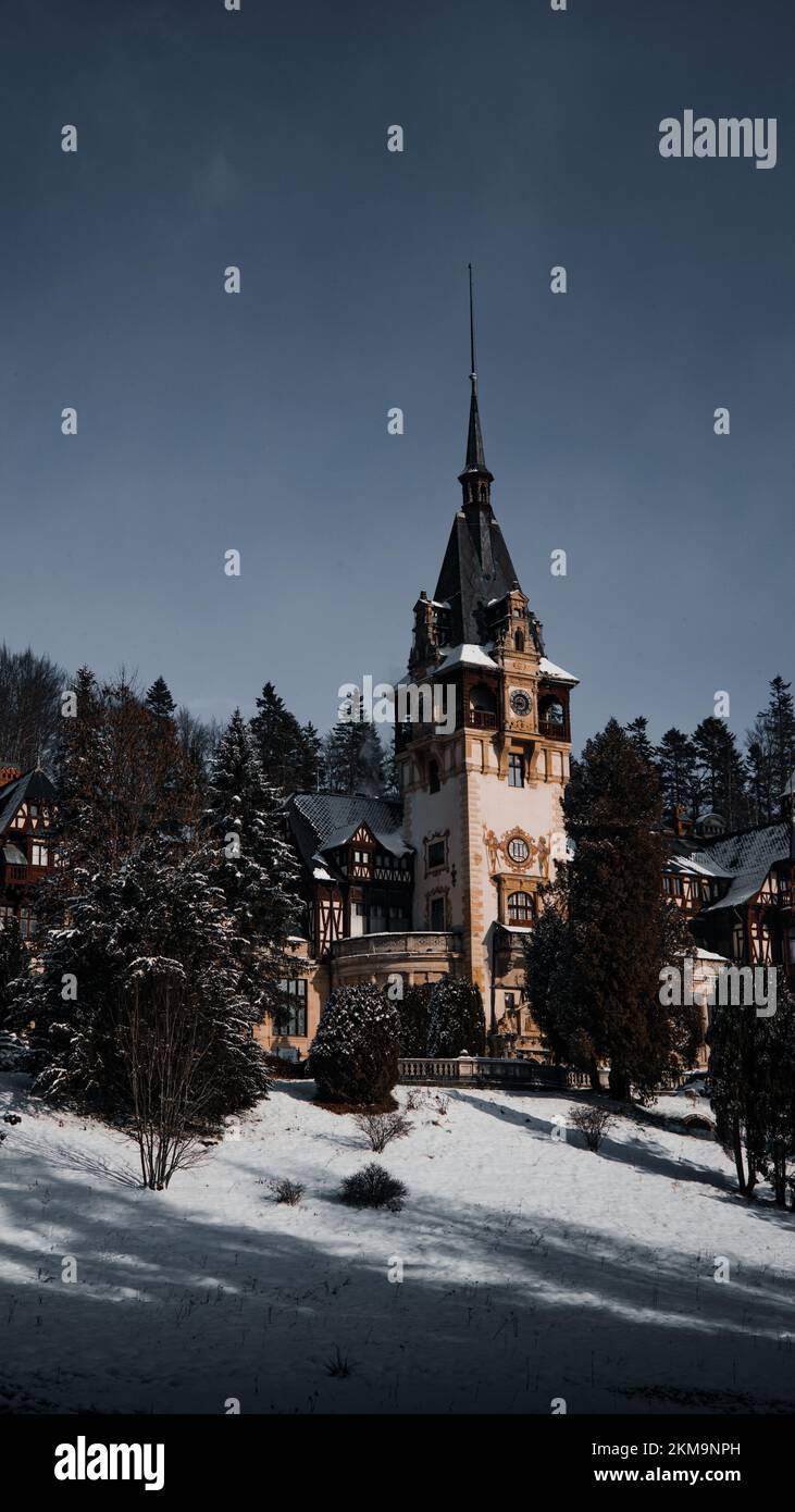 A vertical of the Peles castle in the snow-covered Carpathian Mountains ...