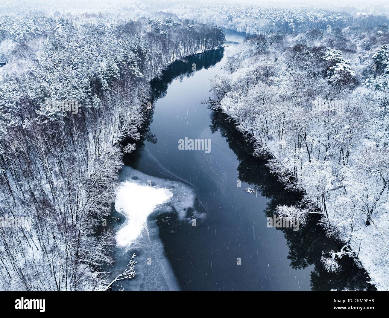 Aerial view of cold river and snowy forest in winter. Aerial view of ...