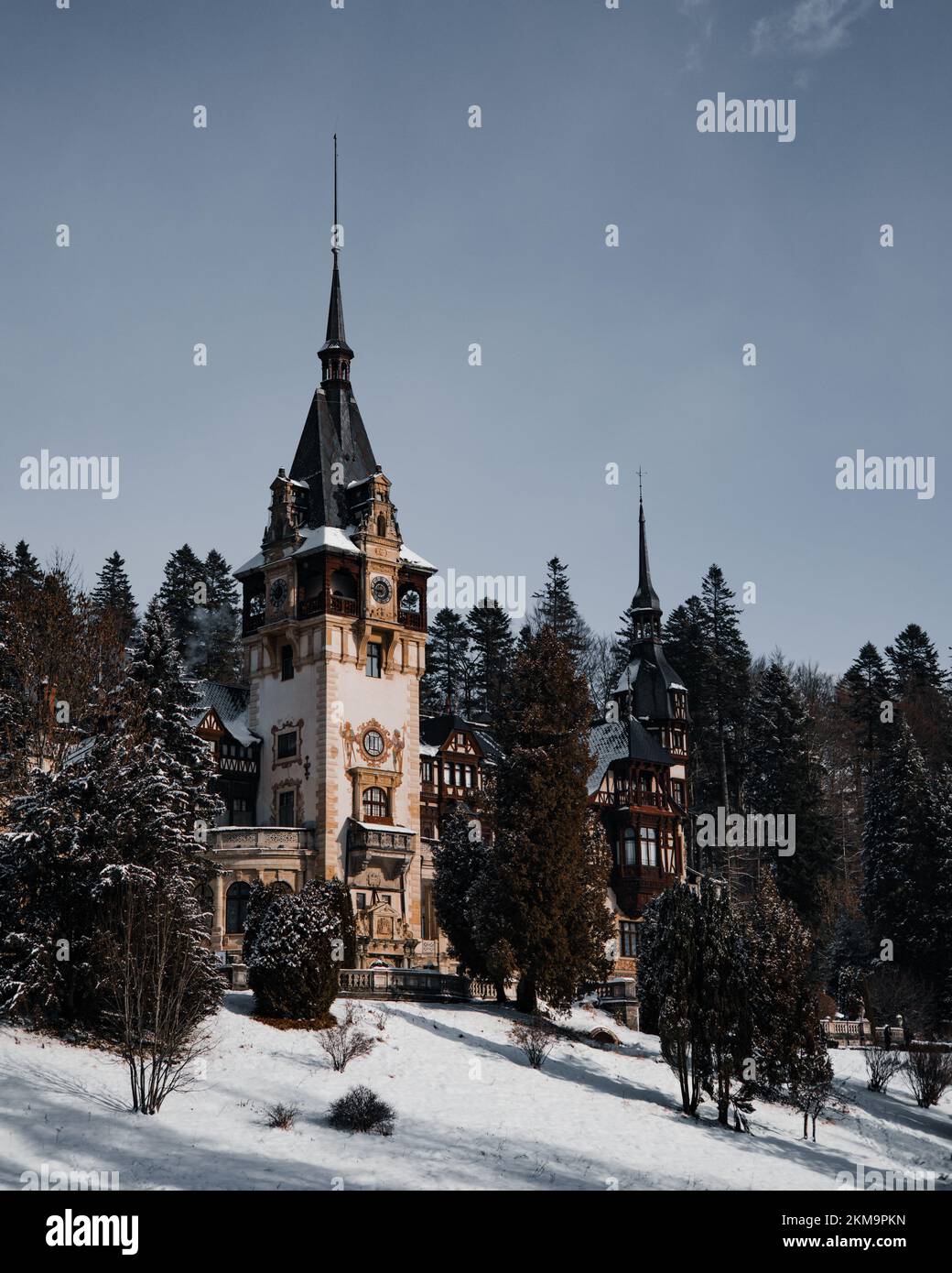 A vertical of the Peles castle in the snow-covered Carpathian Mountains ...