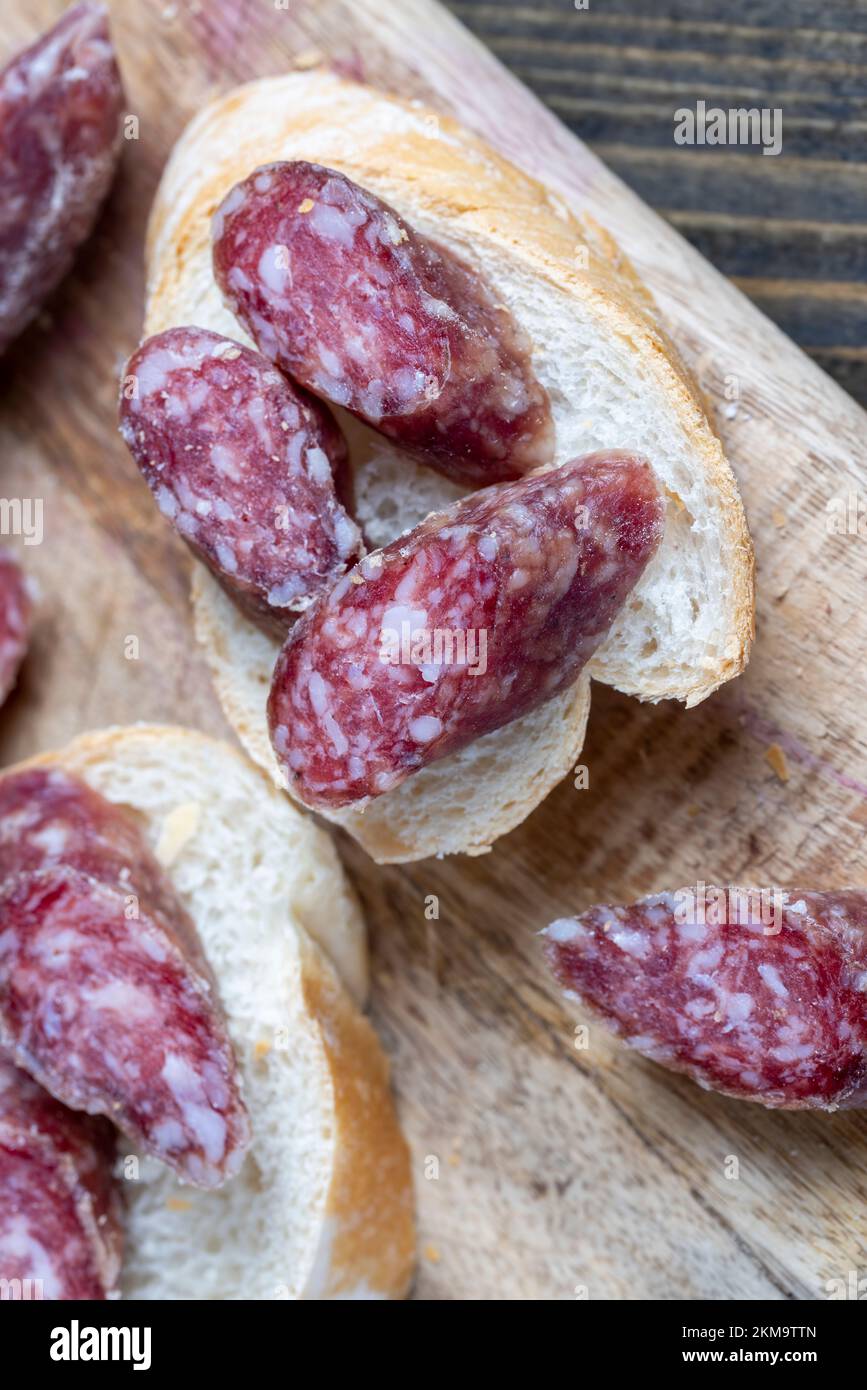 sliced pieces of sausage from meat are lying on a cutting board, pork ...