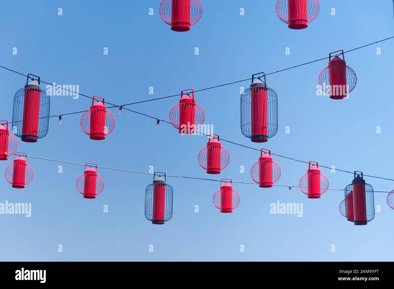 red chinese style lanterns hanging on wires strung between buildings ...