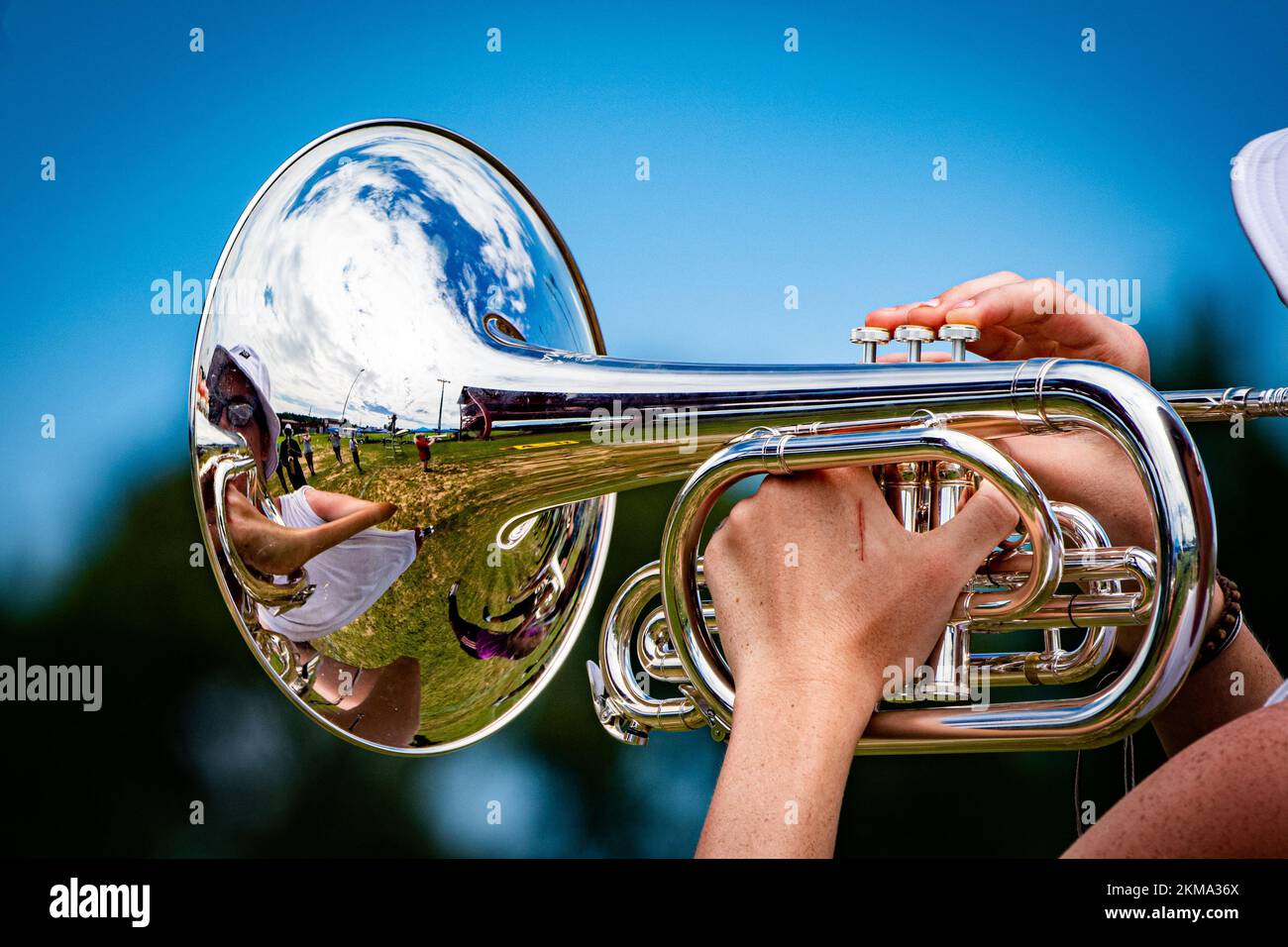 A selective focus of a person's hands playing a marching baritone ...