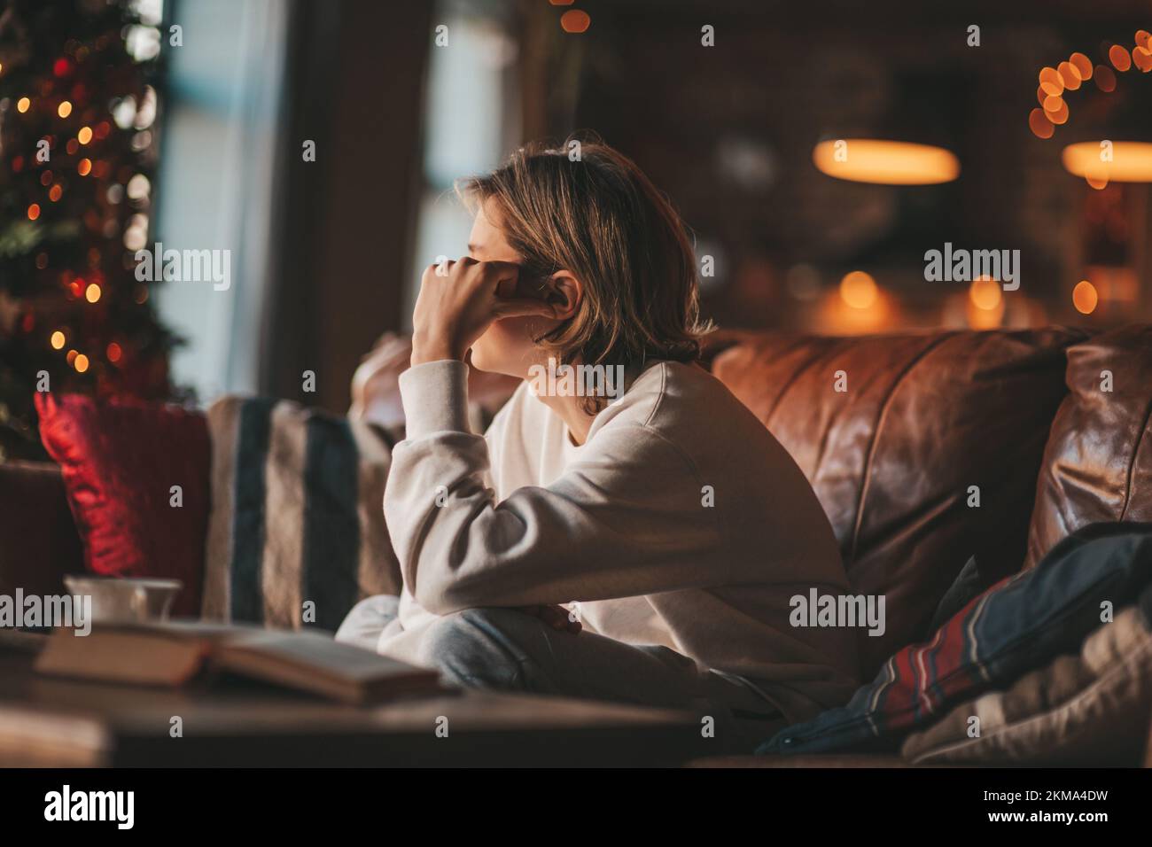 Young teen boy with long hair thoughtful look sad eyes negative mood ...