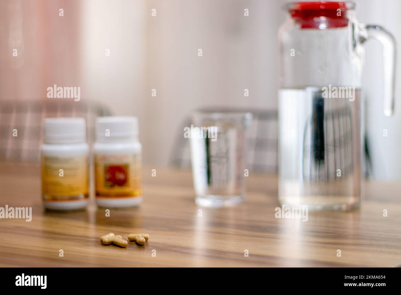Pill capsule medicine and glass of water on wooden background. Side ...