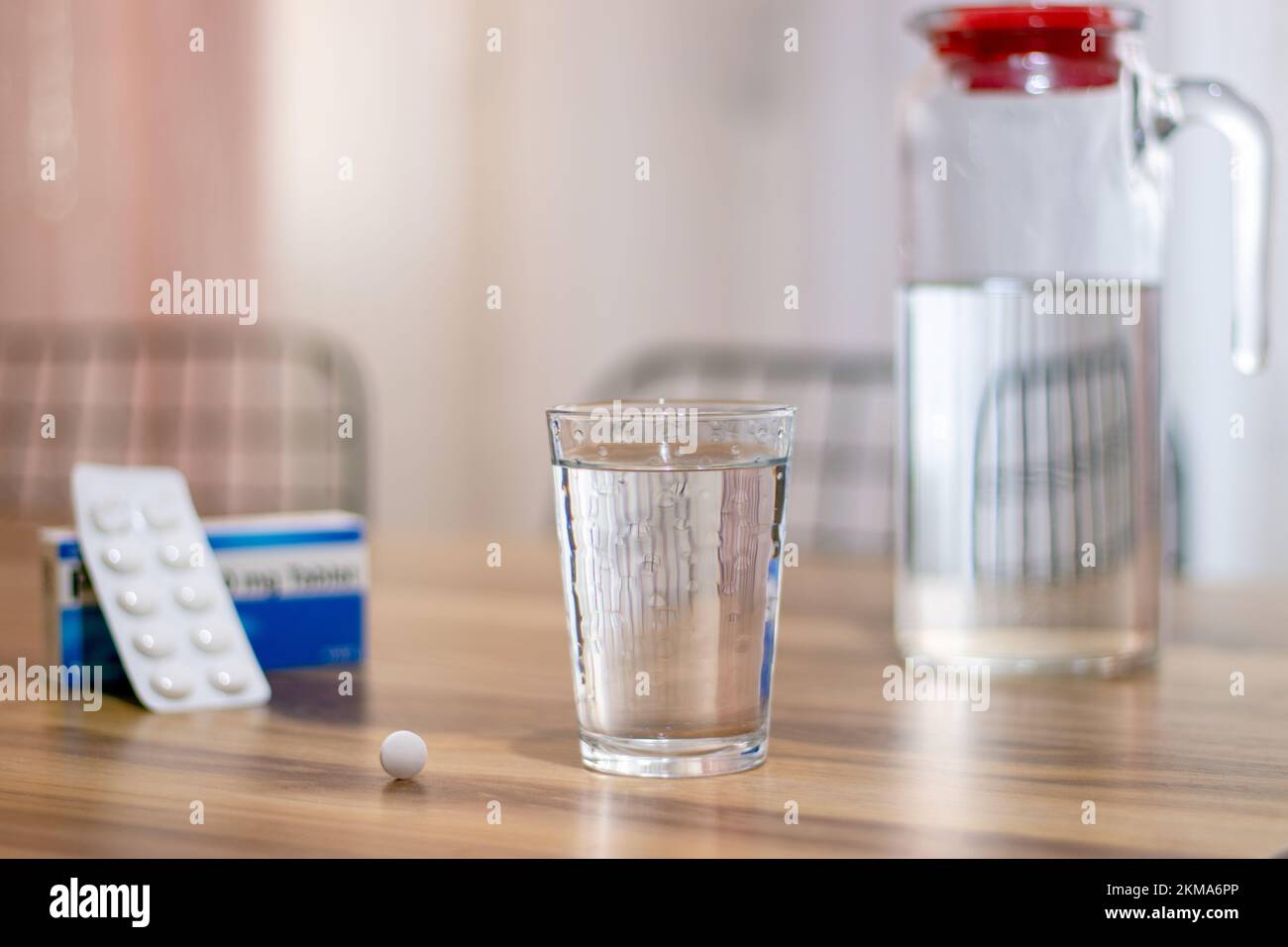 Pill capsule medicine and glass of water on wooden background. Side ...