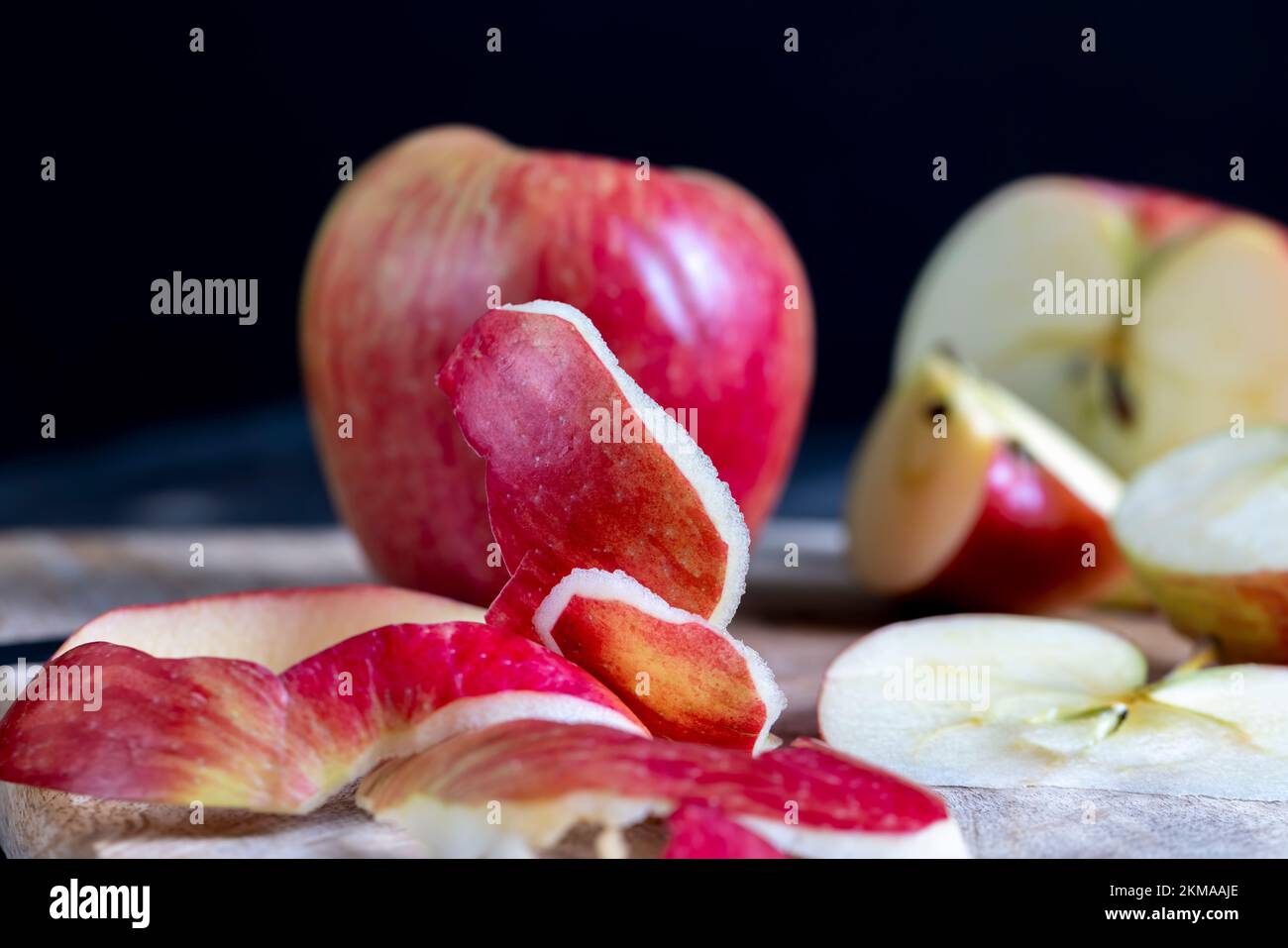 sliced ripe red juicy apple, cutting old board with pieces of red ripe ...