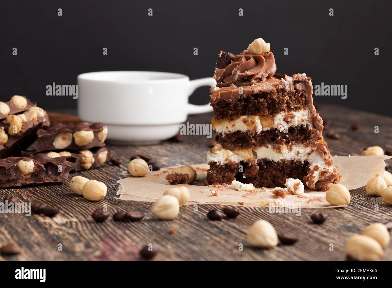 layered cake with chocolate cakes, caramel cream and hazelnuts, a piece ...