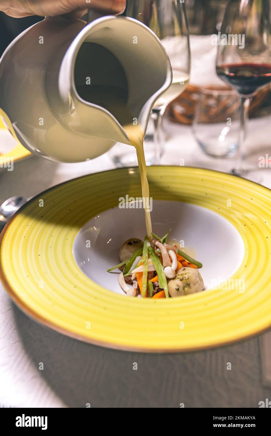 Chef pour soup into plate on the table for luxury dinner party Stock ...
