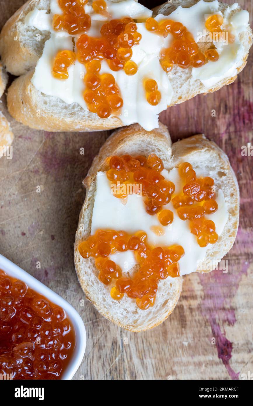 natural red salmon caviar with baguette and butter, making sandwiches ...