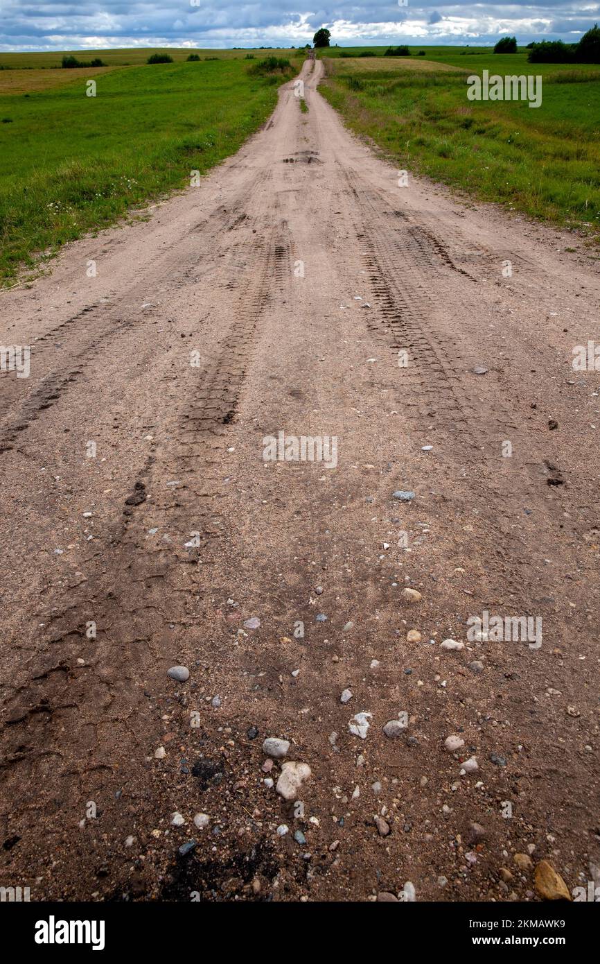 an empty old not paved road , road markings on an not asphalt highway ...
