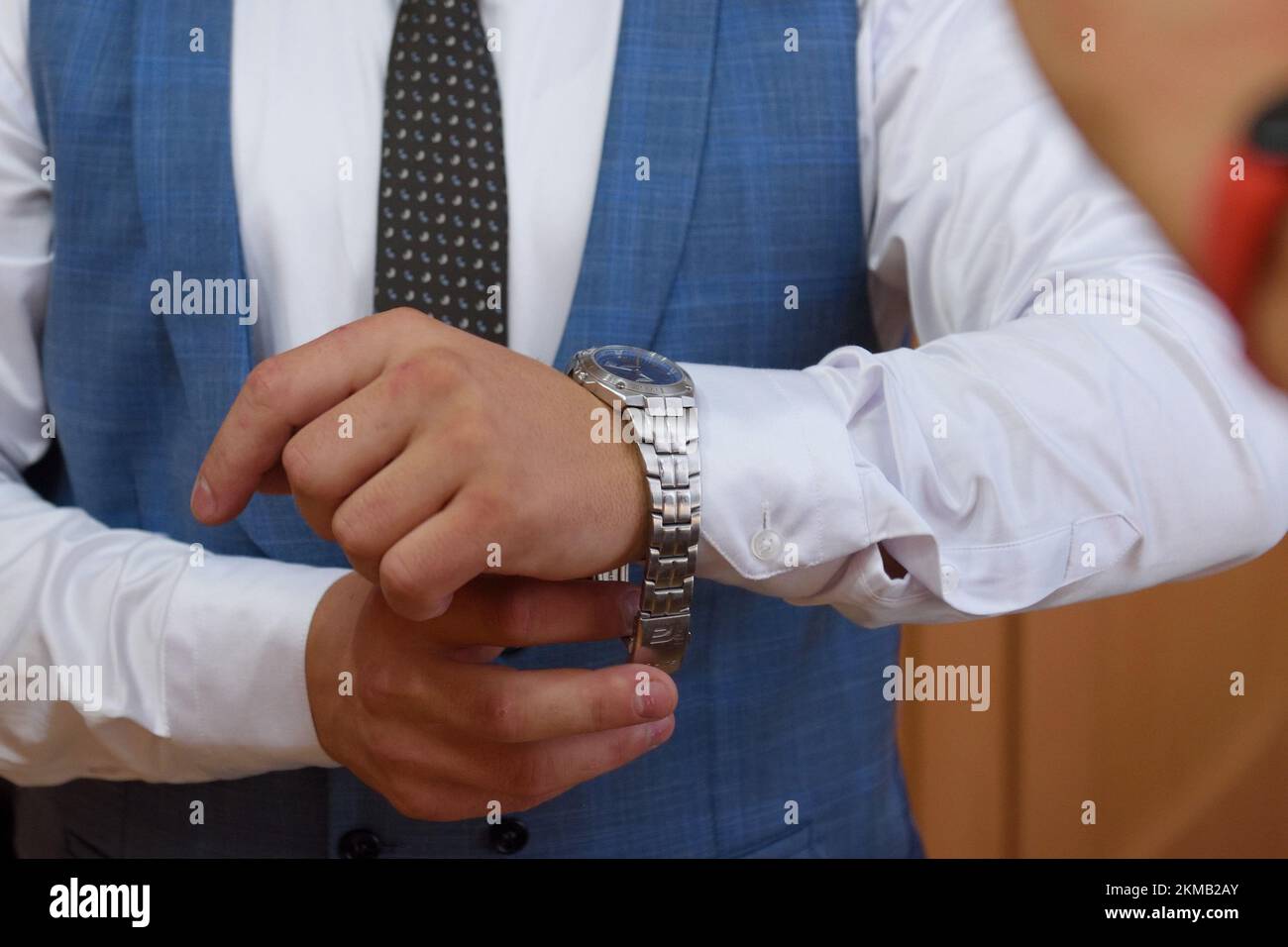 A man with an official look adjusting his clock Stock Photo - Alamy
