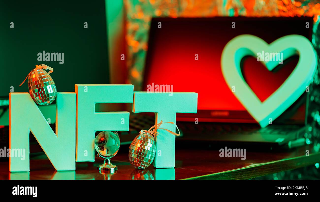 NFT inscription in neon light. NFT lettering at workplace with globe ...
