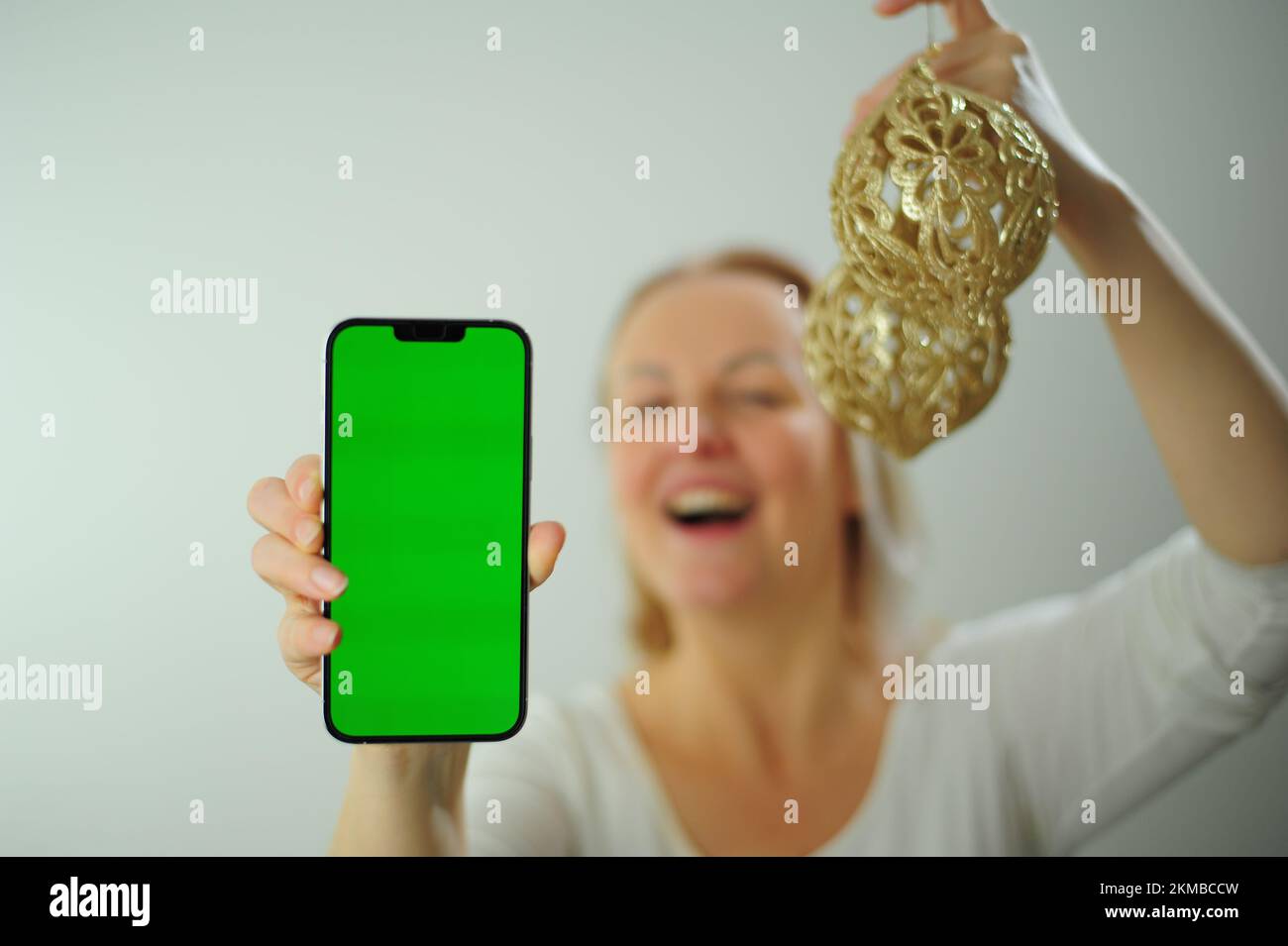 woman with blond hair holds Christmas tree toys in one hand Woman ...