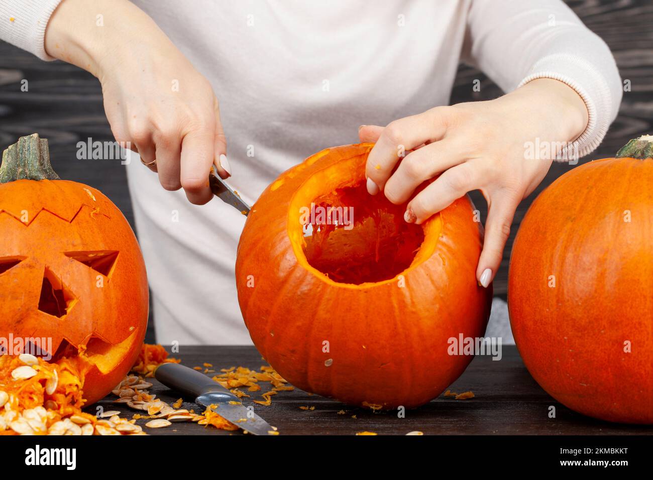 preparing orange pumpkins for Halloween celebration, carved from small ...