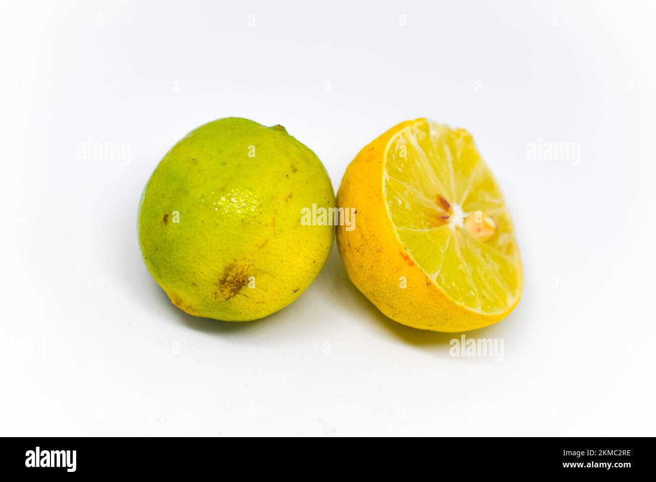 A close-up of a whole and a half lemon (Citrus limon) isolated on a ...