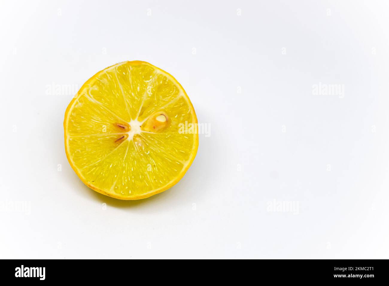 A close-up of a half slice lemon (Citrus limon) isolated on a white ...